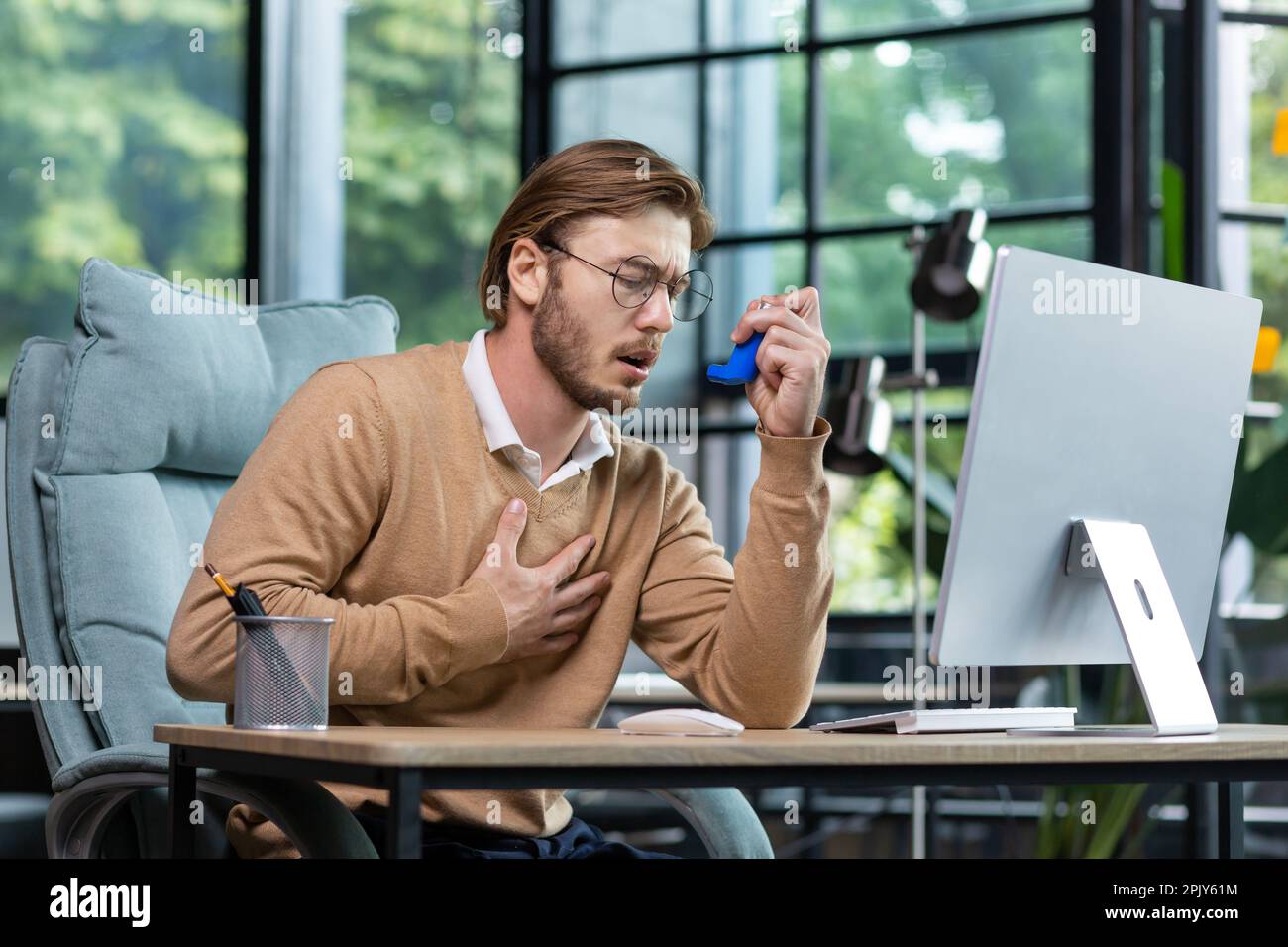 Asthma attack, panic attack. A young man sits in the office at the ...