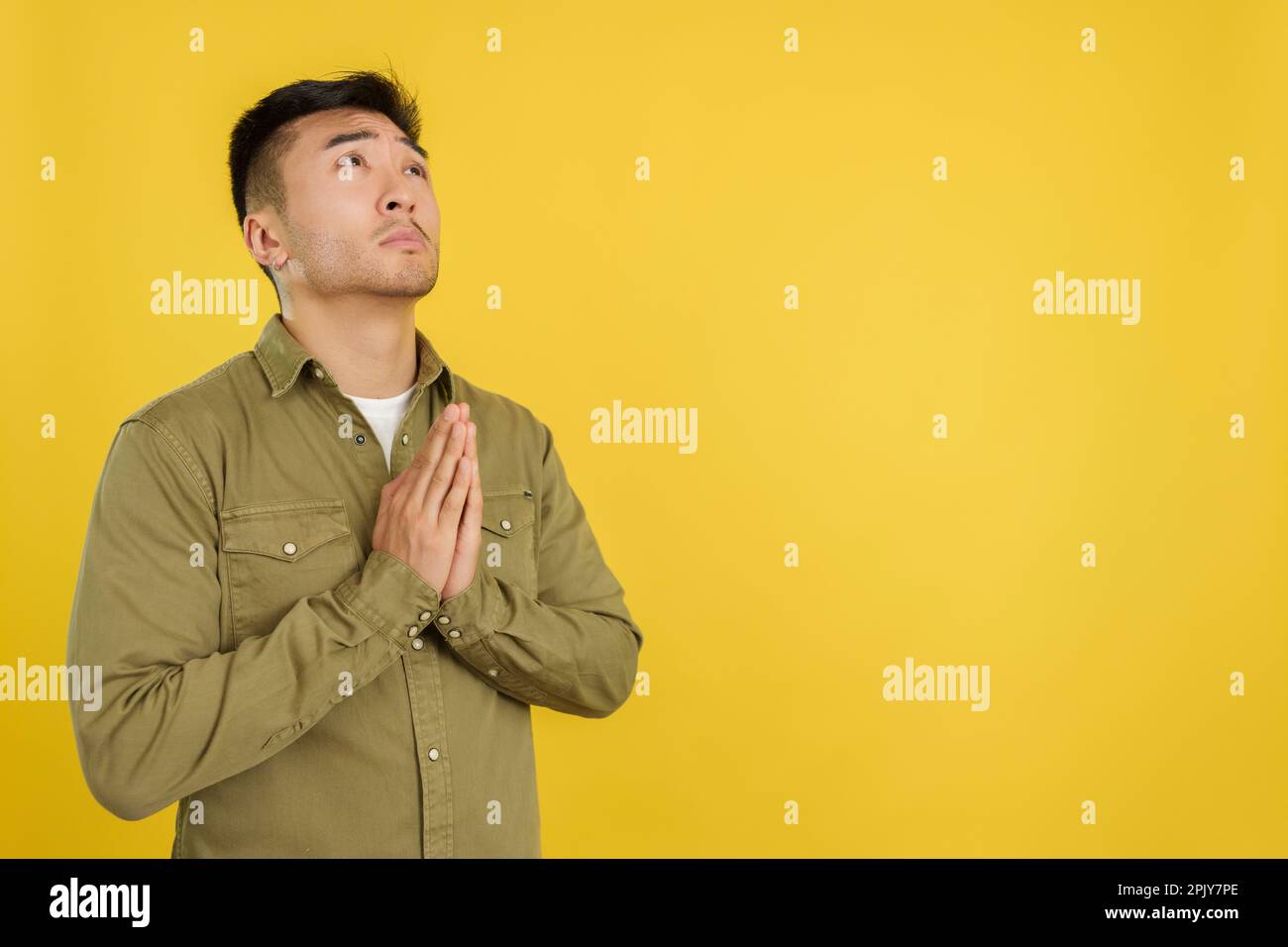 Chinese man looking up while praying with hands folded Stock Photo - Alamy