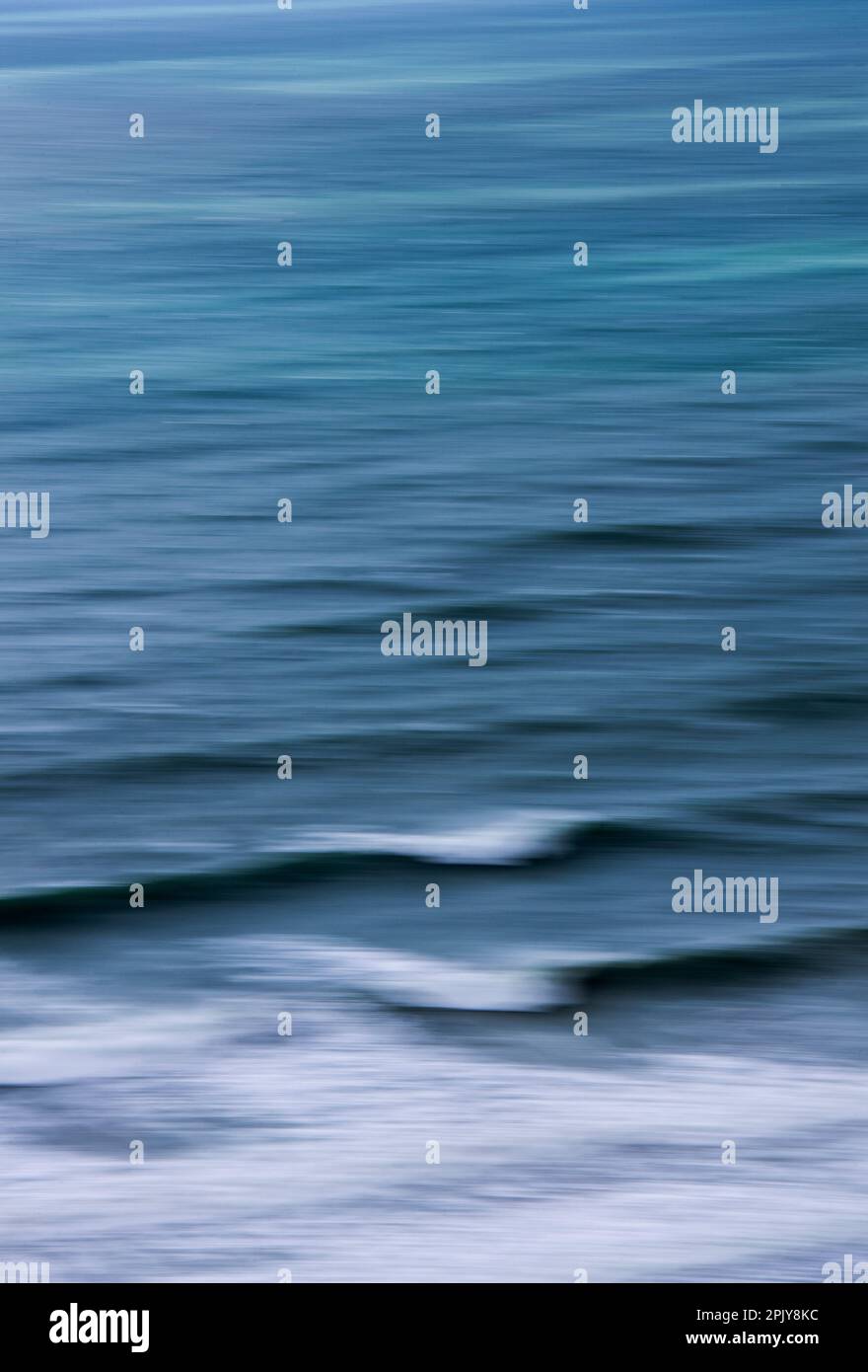 Long exposure of waves and the incoming tide approaching a beach Stock ...