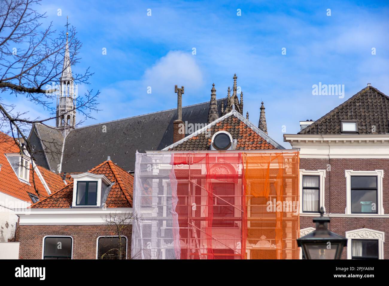 Orange scaffolding with protective net against historic building to ...
