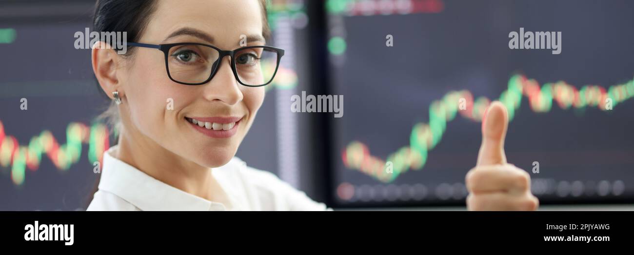 Happy woman trader showing thumb up gesture Stock Photo - Alamy