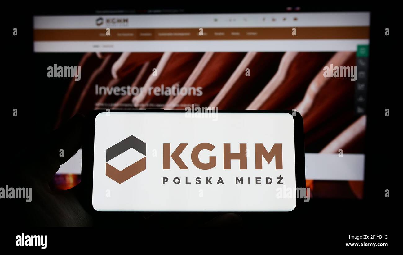 Person holding smartphone with logo of Polish mining company KGHM ...