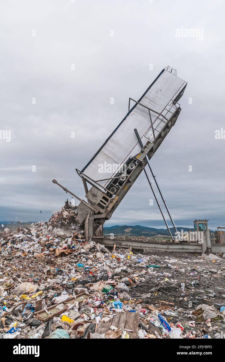Landfill tipper lifts trailer container to a high angle to dump all the ...