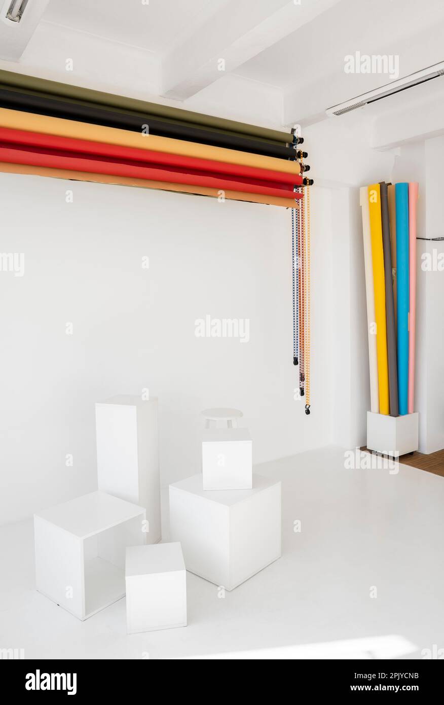 Sunny daylight photo studio interior with set rolls of color background ...