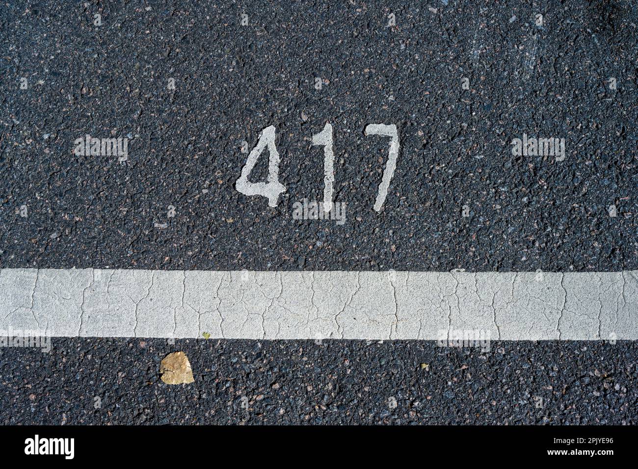 Asphalt with number 417 in white paint Stock Photo - Alamy