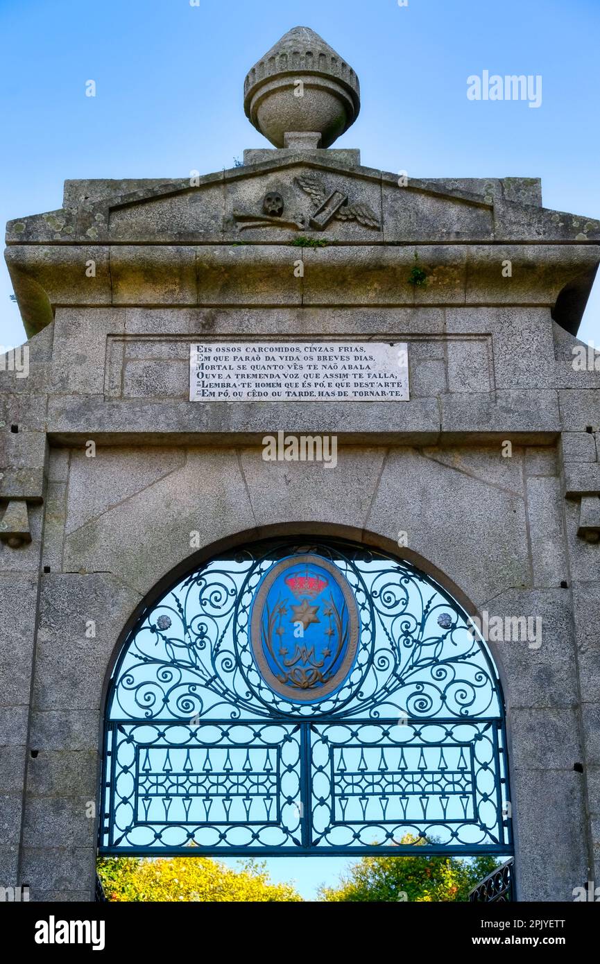 Stone arch gate to the temple cemetery. There is a coat of arms and a ...