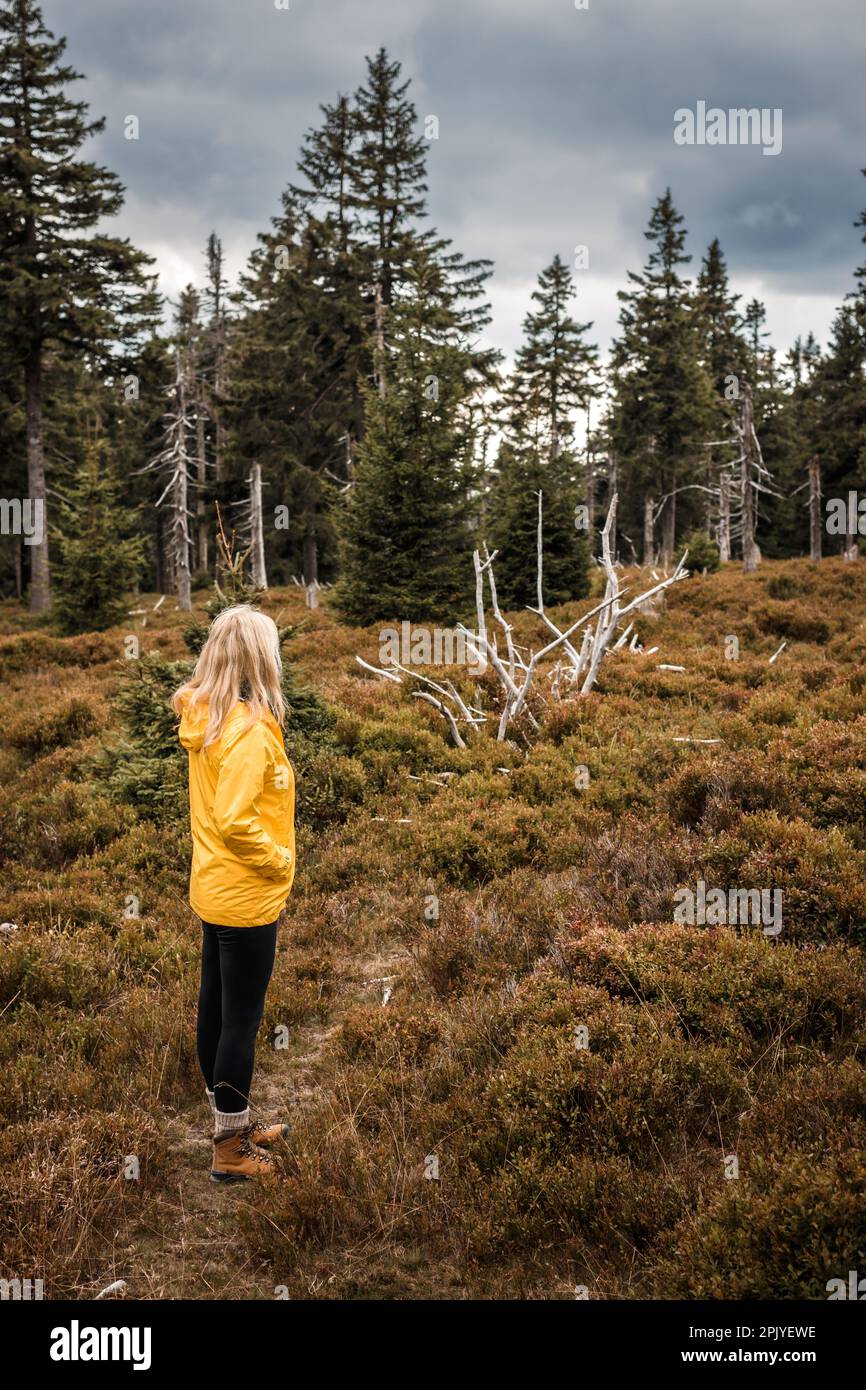 Woman wearing yellow waterproof jacket to protect against bad weather ...