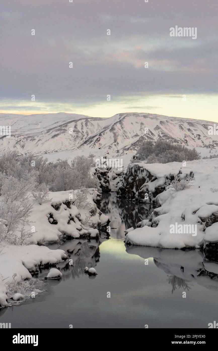 Landscape, mountain and snowy trees and river reflecting the sky of ...