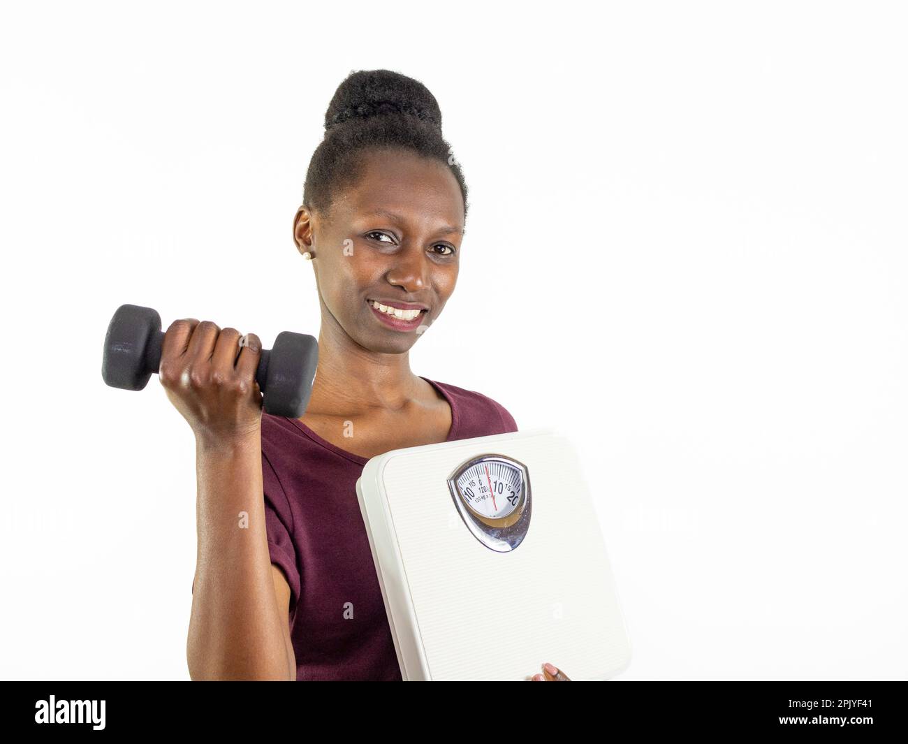 Young woman showing a weight scale while lift a dumbbell isolated on ...