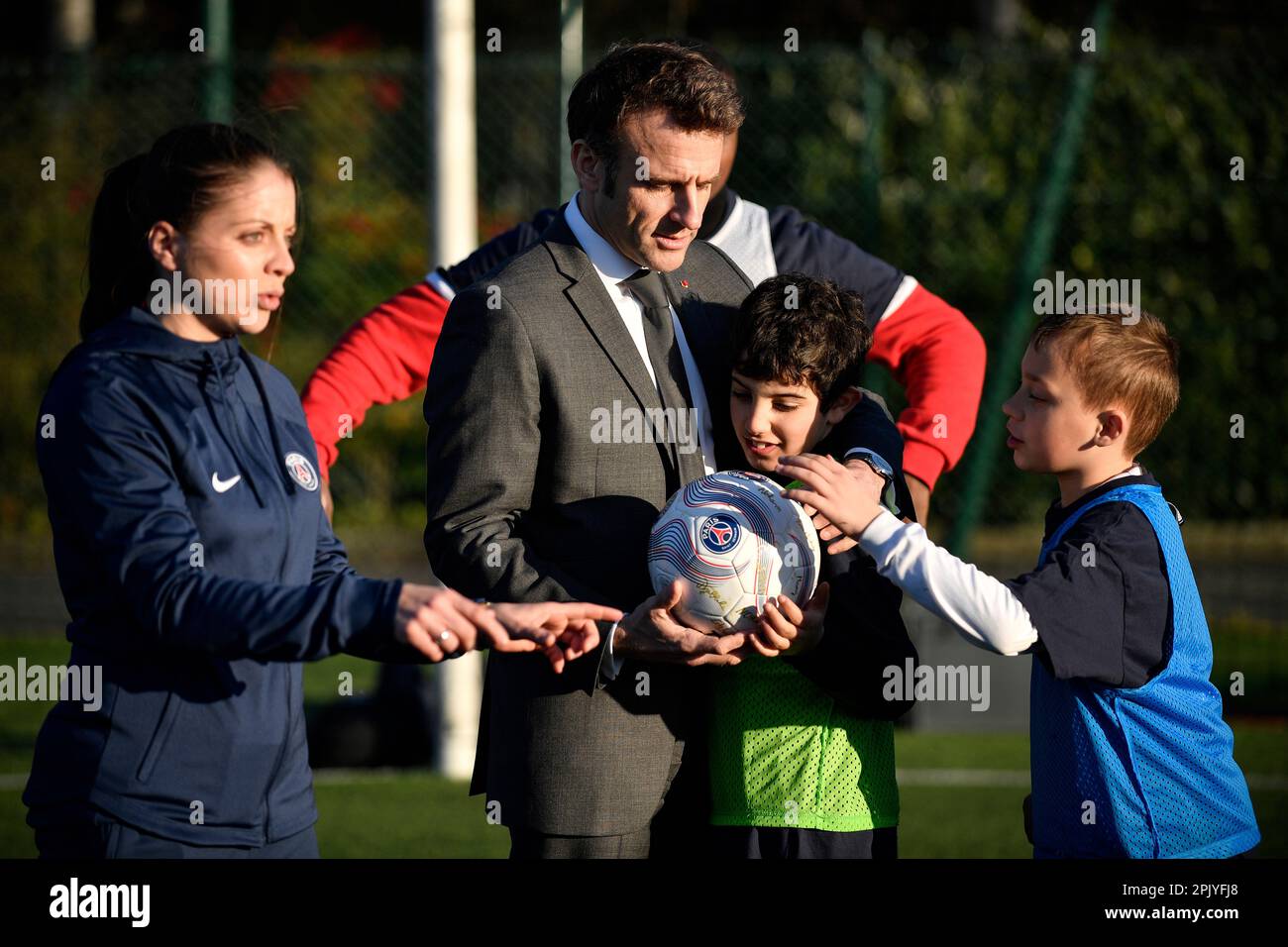 French President Emmanuel Macron holds a ball as he attends a soccer ...