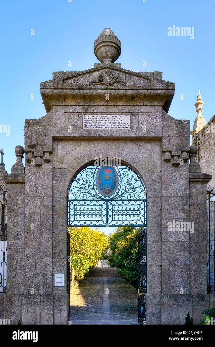 Stone arch gate to the temple cemetery. There is a coat of arms and a ...