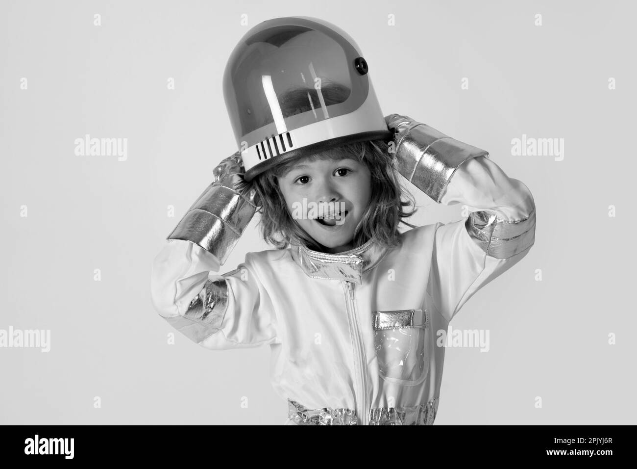 Close-up face of little astronaut with helmet looking dreamily. Little ...