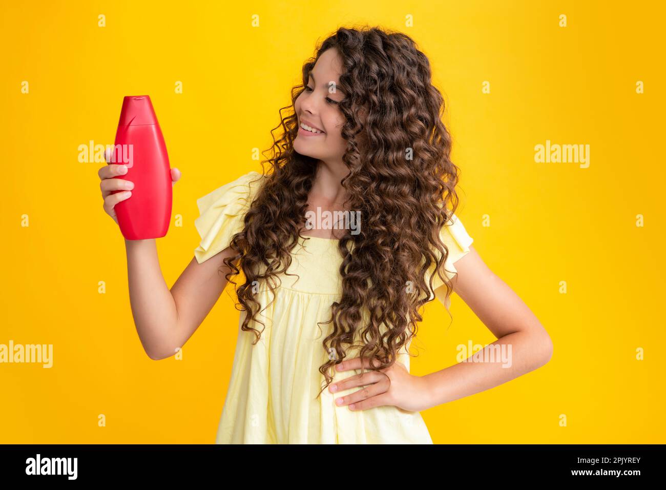 Happy portrait of child teen girl with shampoos conditioners and shower ...