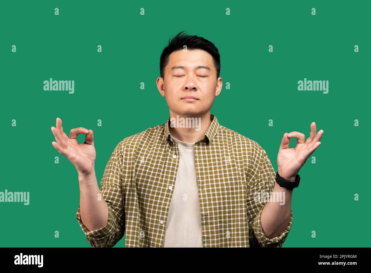 Stress relief concept. Asian man meditating with closed eyes, keeping ...