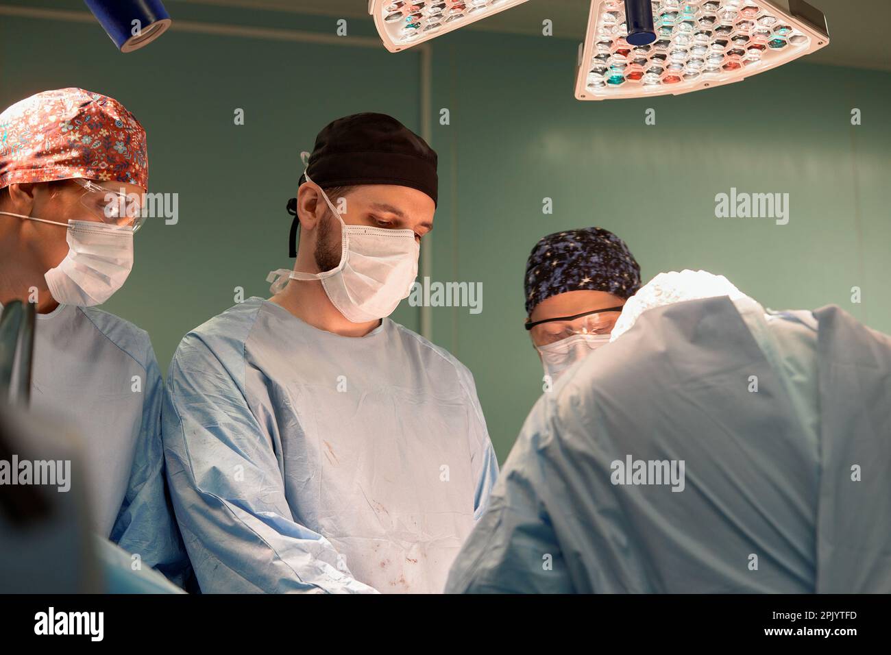 Shot of two experienced surgeons and an alert nurse performing an ...