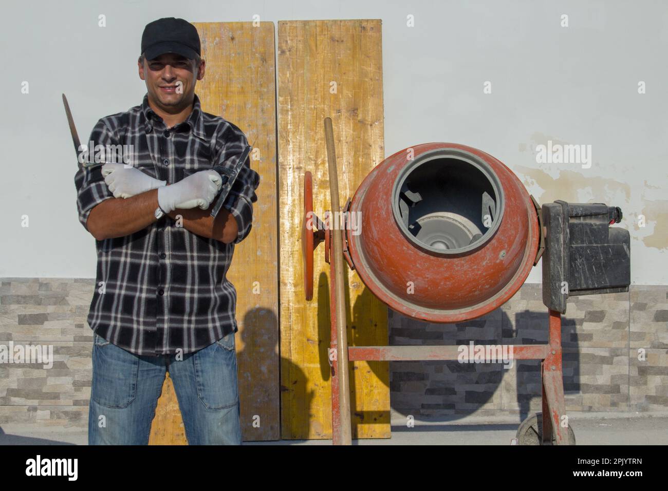 Image of a smiling construction worker with concrete mixer and ...
