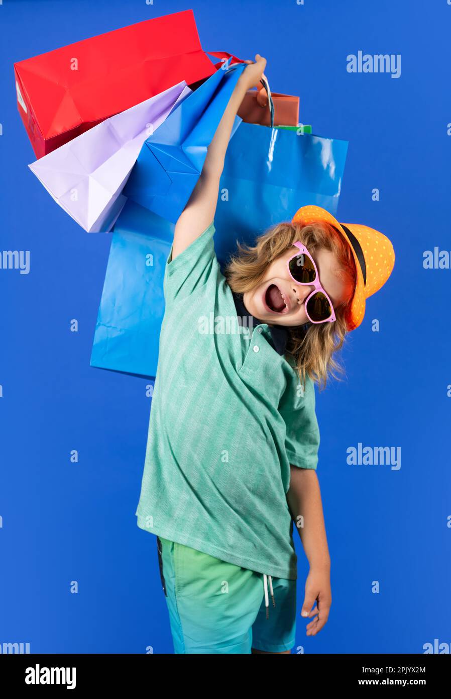 Fashion child on shopping. Portrait of a kid with shopping bags. Happy ...