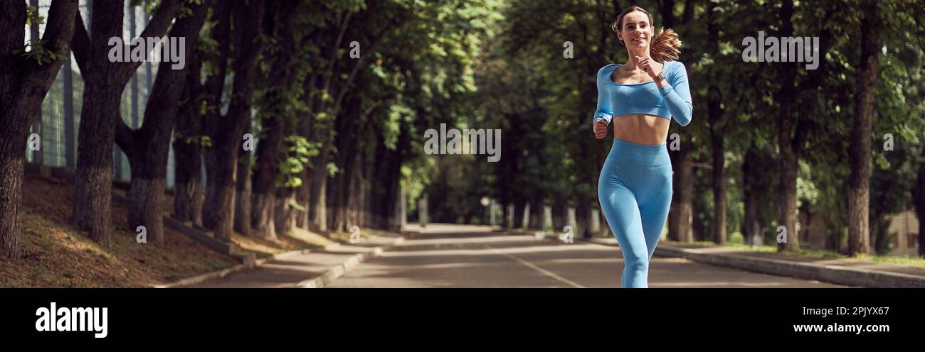 Beautiful fit young woman jogger is running outdoors Stock Photo - Alamy