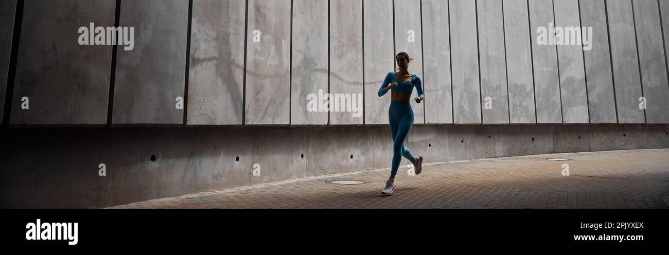 Beautiful fit young woman jogger is running outdoors Stock Photo - Alamy