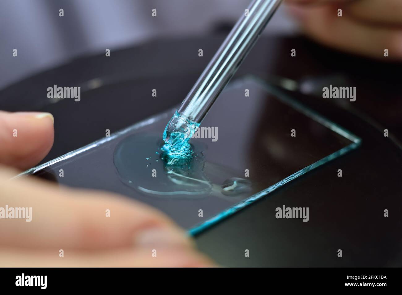 pipette takes a sample of blue liquid, extra close up Stock Photo - Alamy