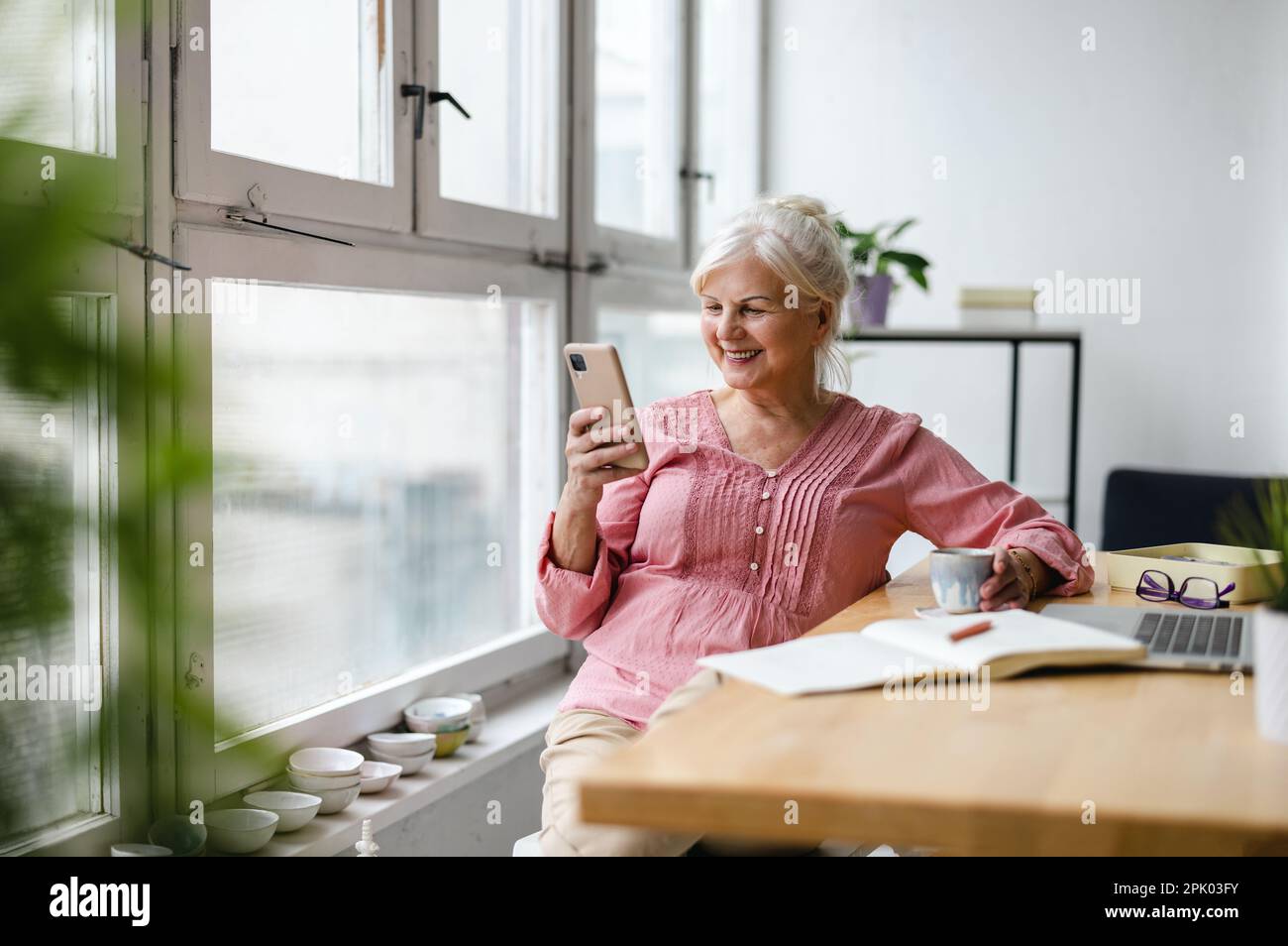 Elderly woman using phone working hi-res stock photography and images ...