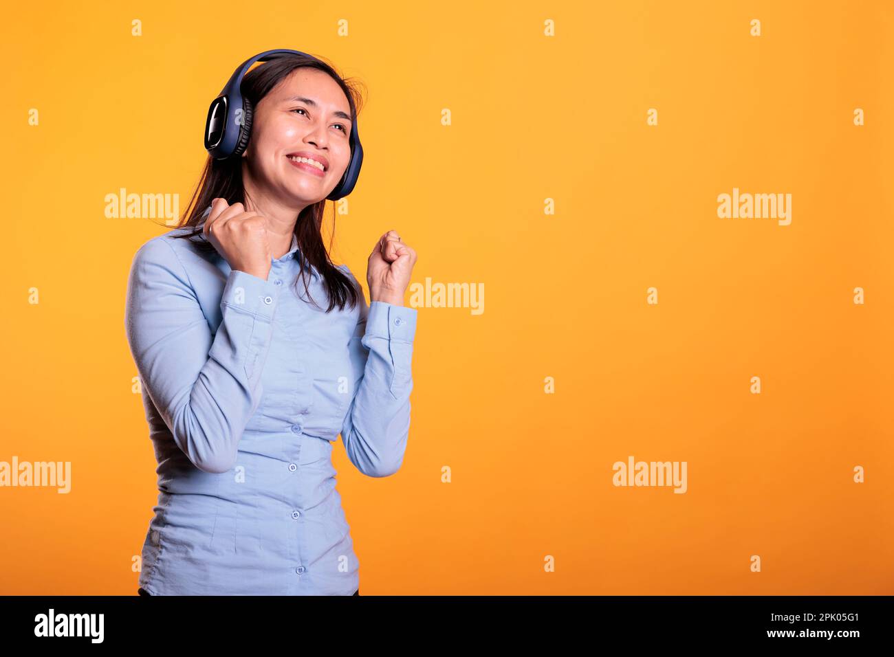 Cheerful confident woman having fun listening music in studio, enjoying ...