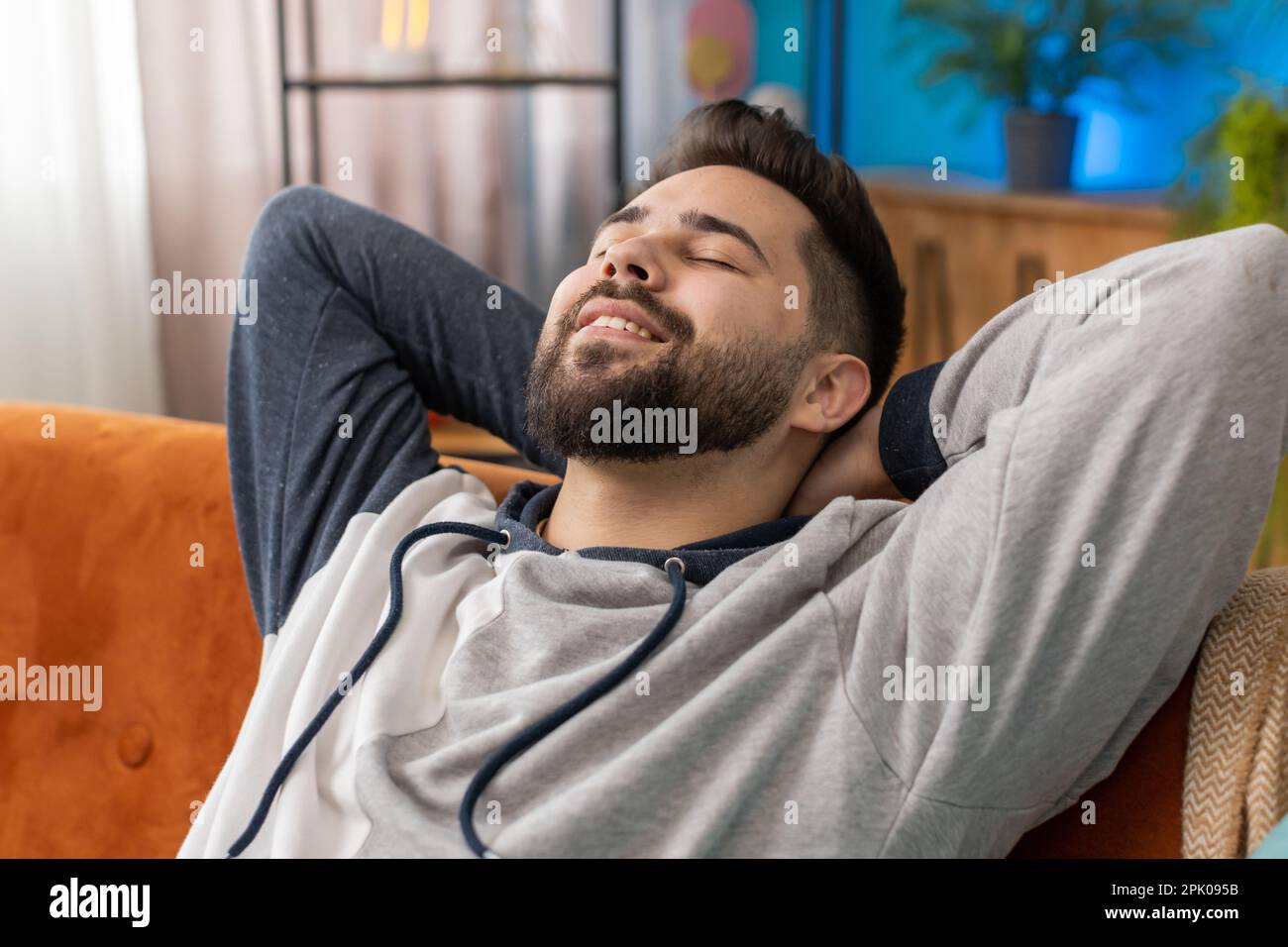 Tired Caucasian man lying down on comfortable couch, taking a rest ...