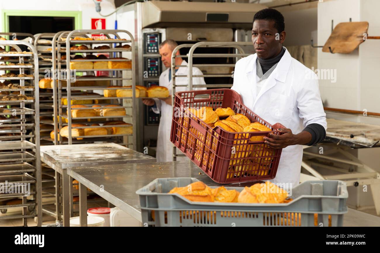 African bakery worker carrying box with loaves Stock Photo - Alamy