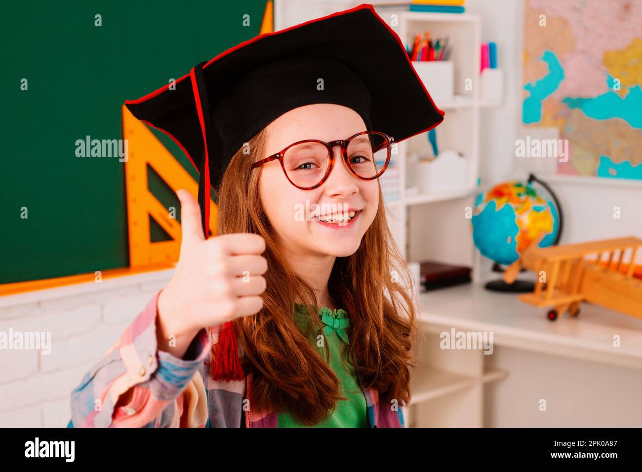 Funny pupil at the desk. Little girl from primary school. Portrait of ...