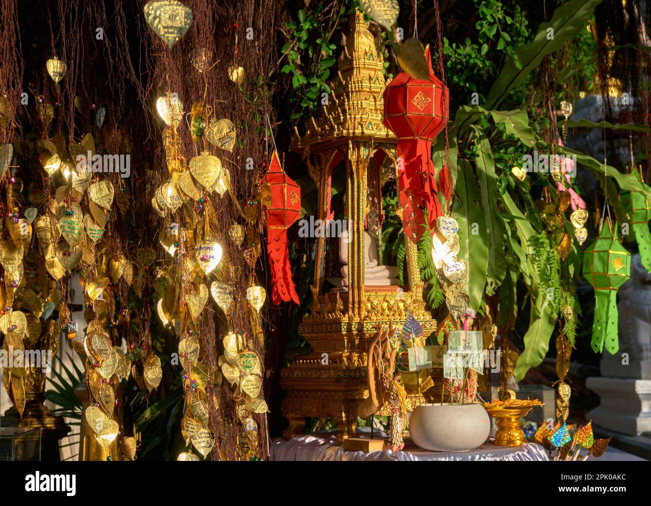 Thai Buddha altar, offerings, lanterns, golden leaves of Bodhi tree ...