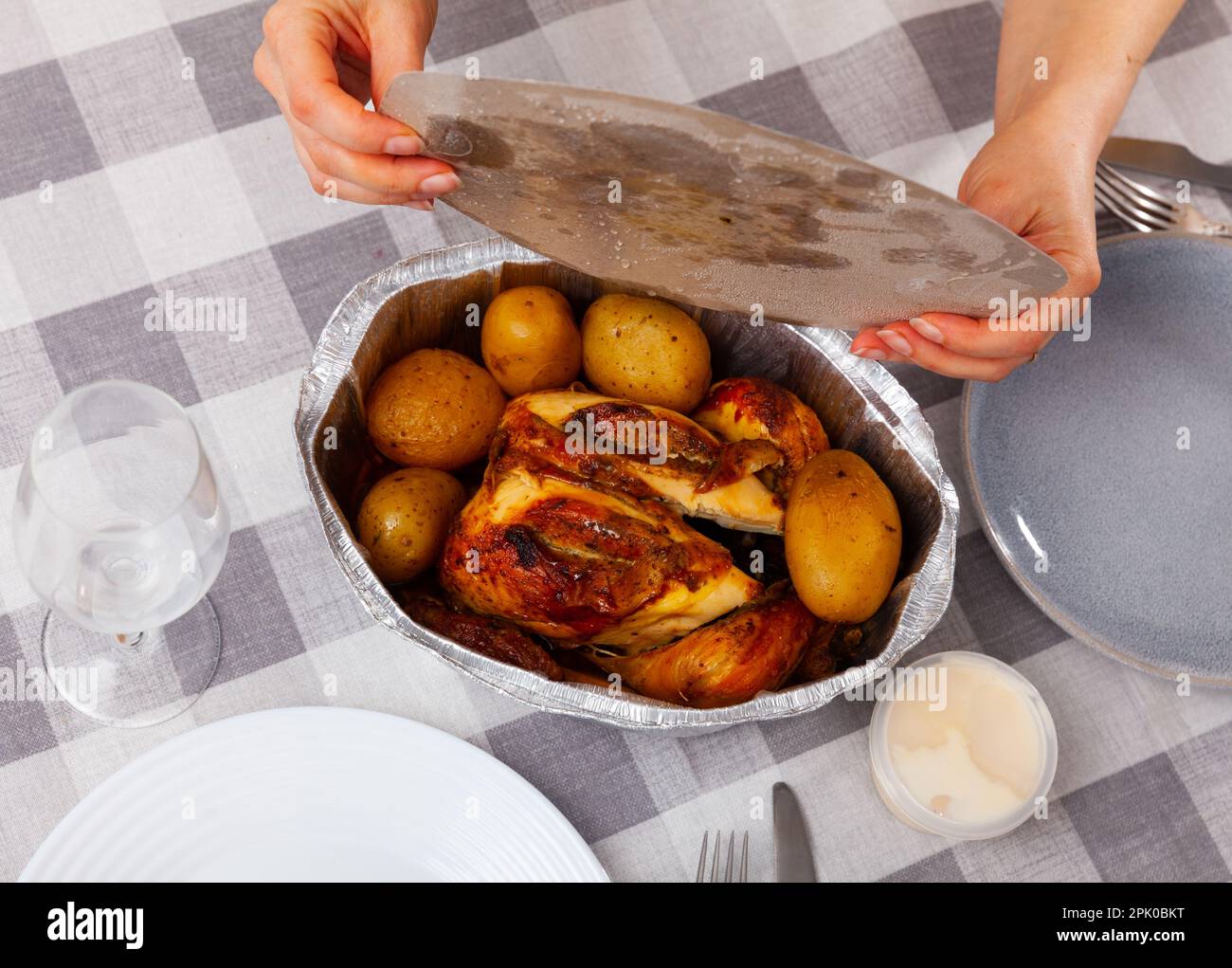Whole chicken baked with potatoes in tinfoil deep bowl Stock Photo - Alamy