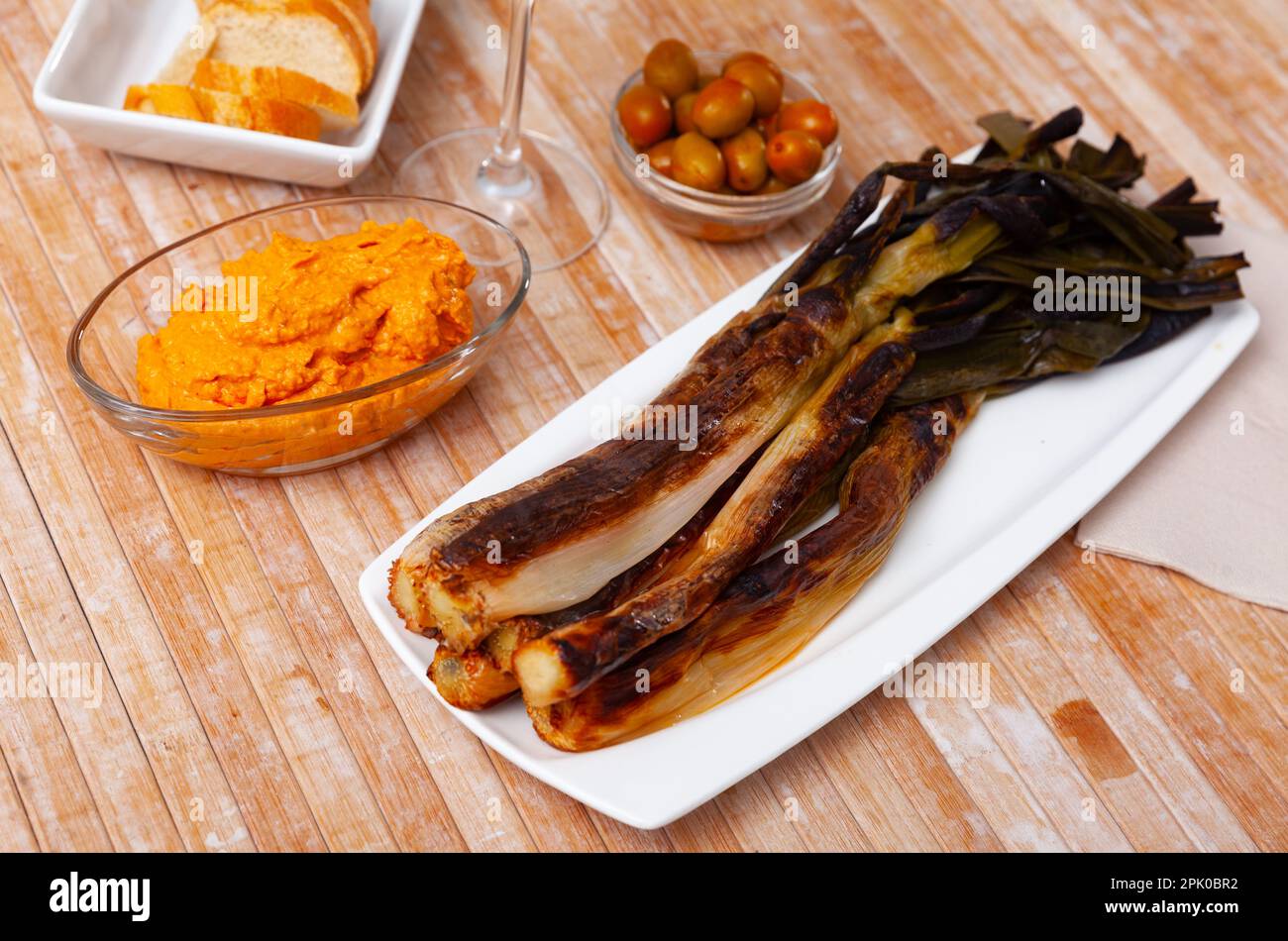 A traditional catalan dish of charred calcot onion and romesco sauce ...
