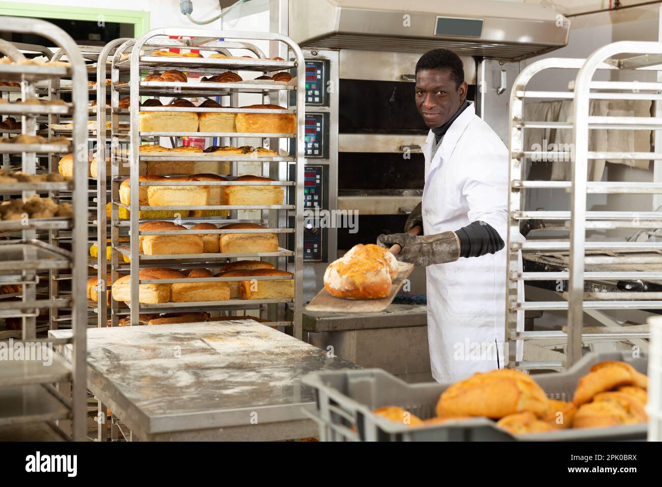 African baker pulling loaves from oven Stock Photo - Alamy