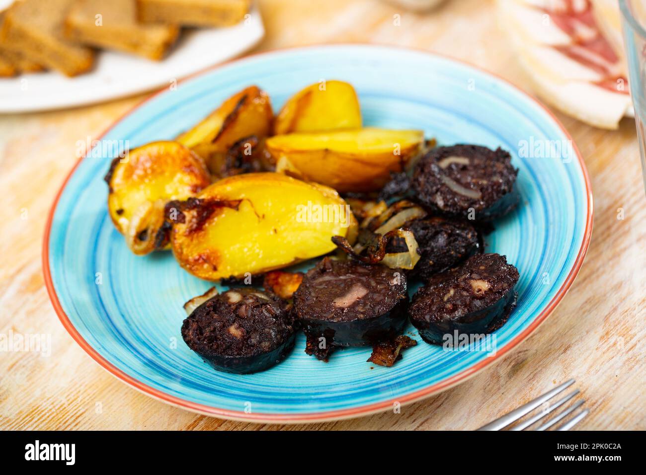 Fried blood sausage with potatoes served at plate Stock Photo - Alamy