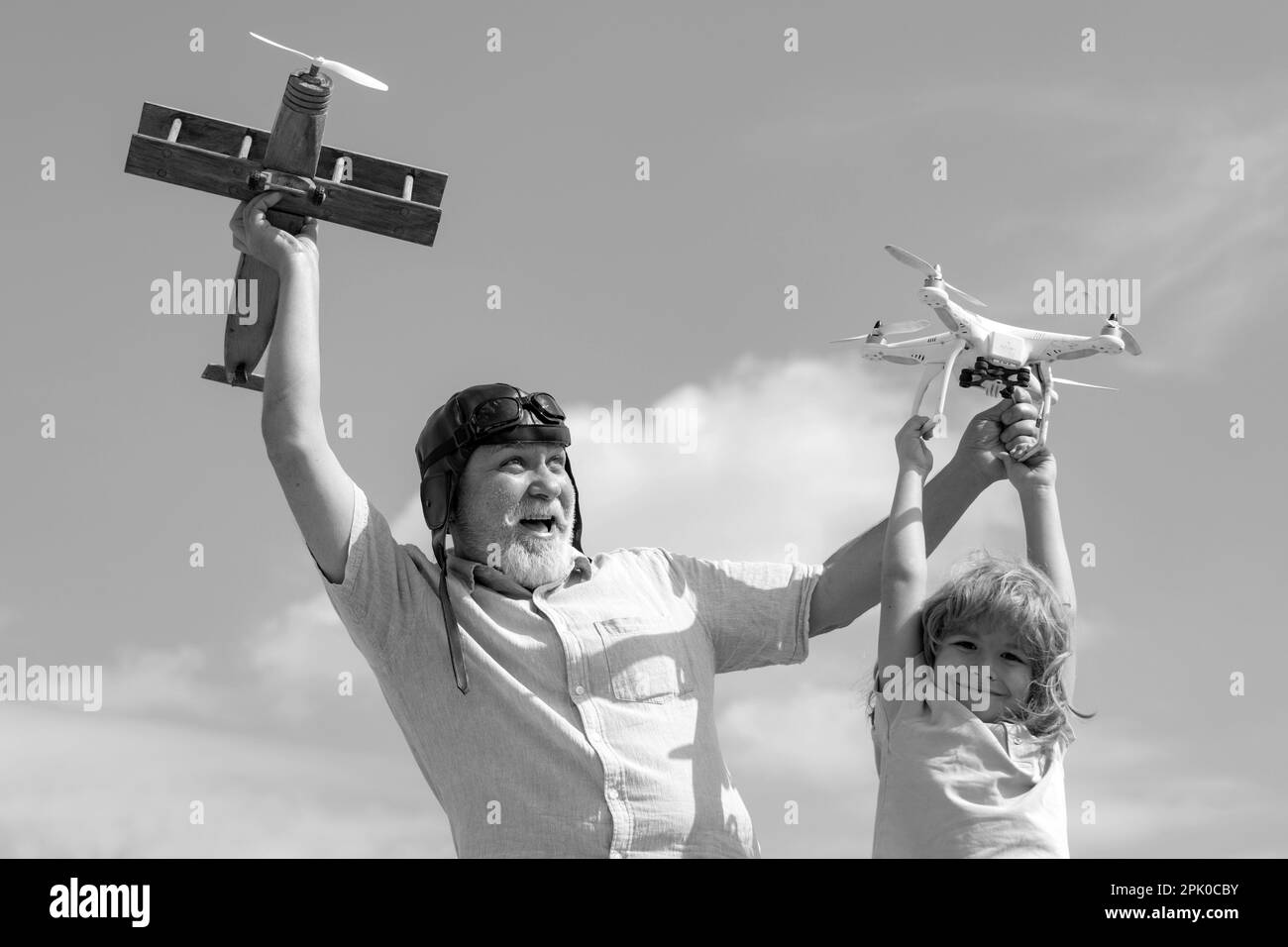 Child boy and grandfather playing with toy plane and quadcopter drone ...