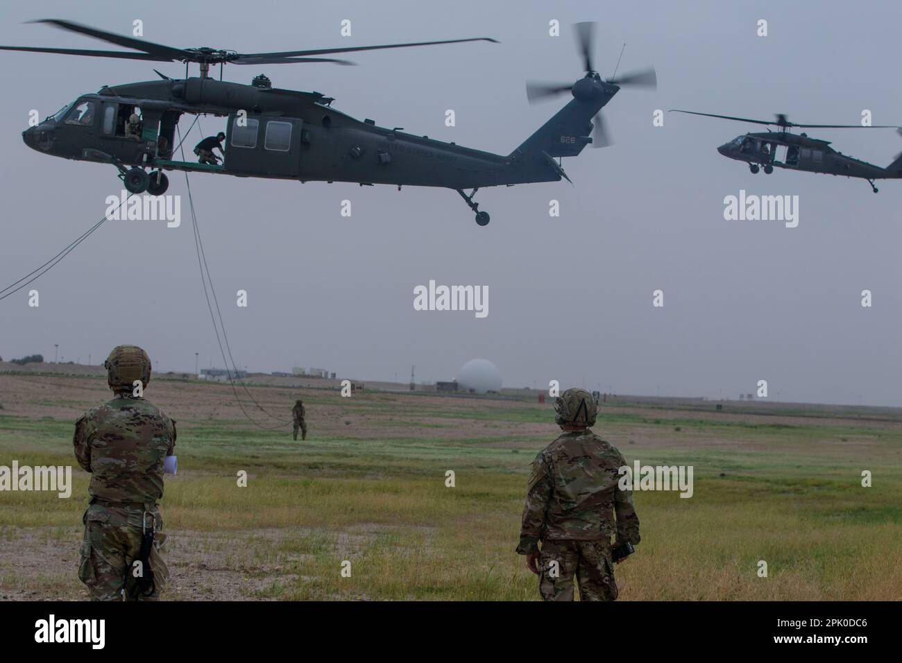 Soldiers look on as the rappel master instructors prepare to ...