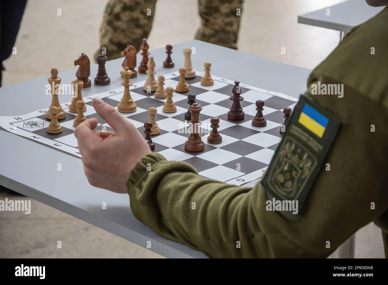 A hand of a man in a military uniform with a Ukrainian flag on his ...
