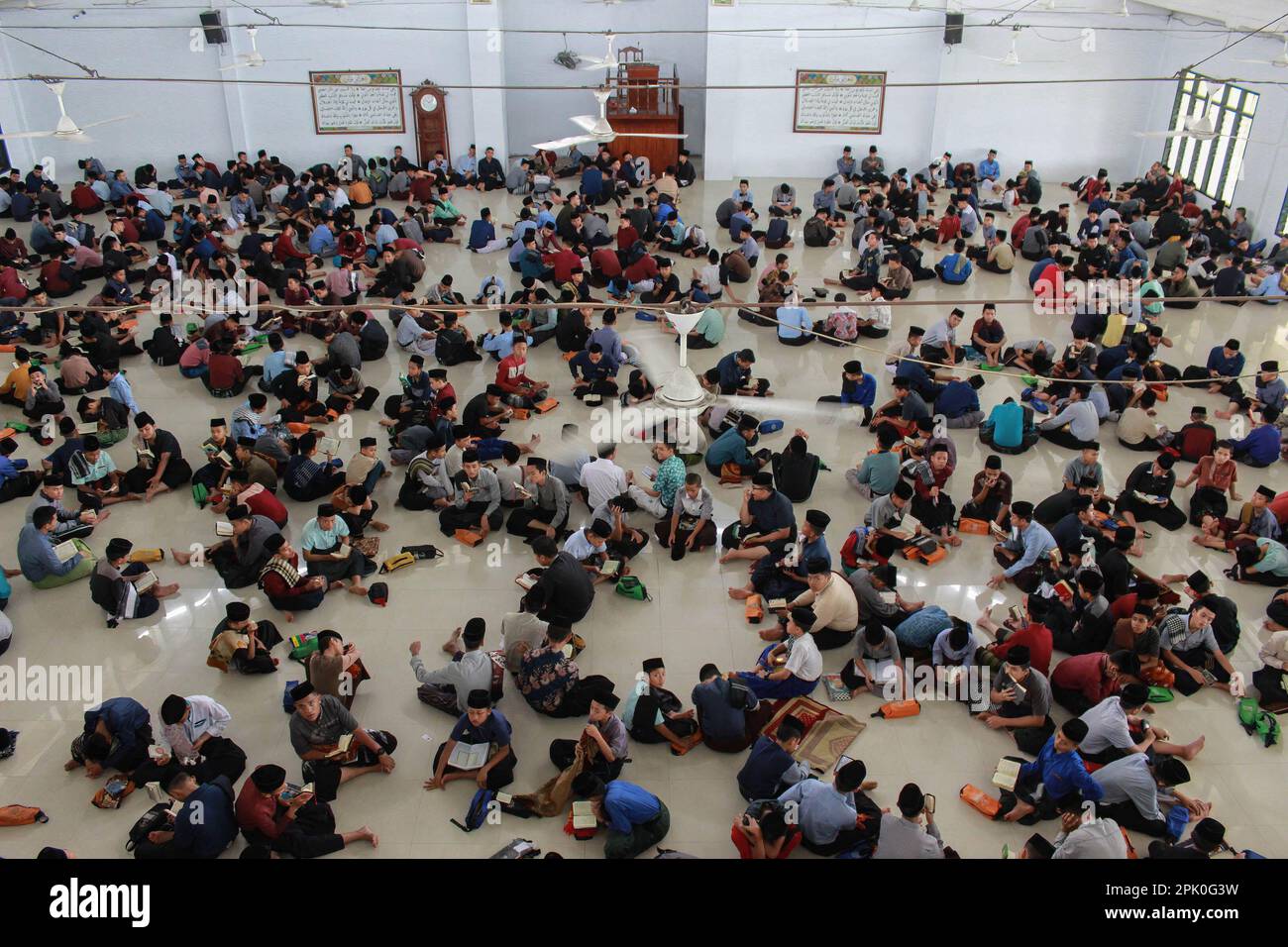 Muslim students sit in circles during a Koran recital class in the holy ...