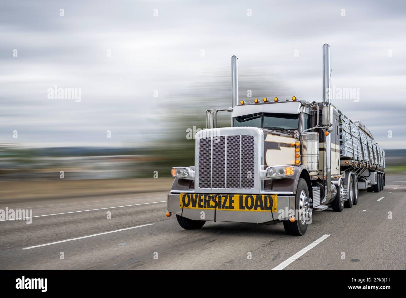 Classic beige big rig semi truck tractor with oversize load sign on the ...