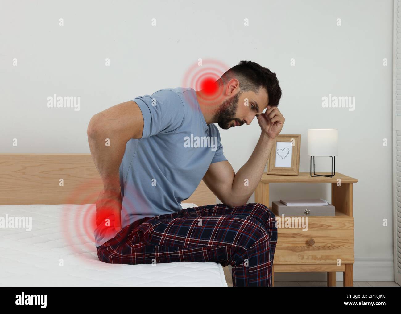 Man suffering from back pain after sleeping on uncomfortable mattress ...