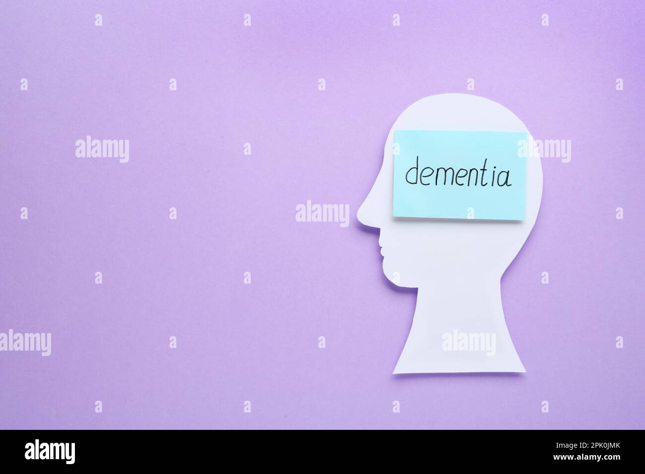 Human head cutout and note with word Dementia on violet background, top ...