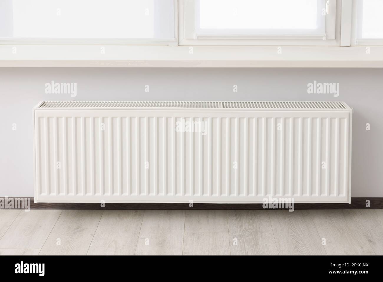 Modern radiator in room. Central heating system Stock Photo - Alamy