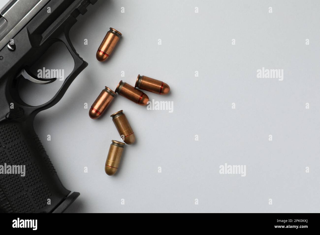 Semi-automatic pistol and bullets on light background, flat lay. Space ...