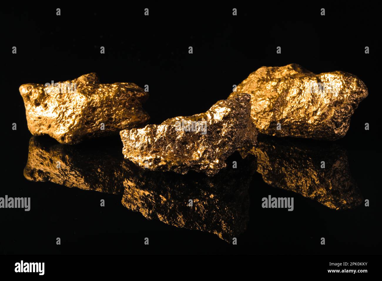 Beautiful gold nuggets on black reflective surface Stock Photo - Alamy
