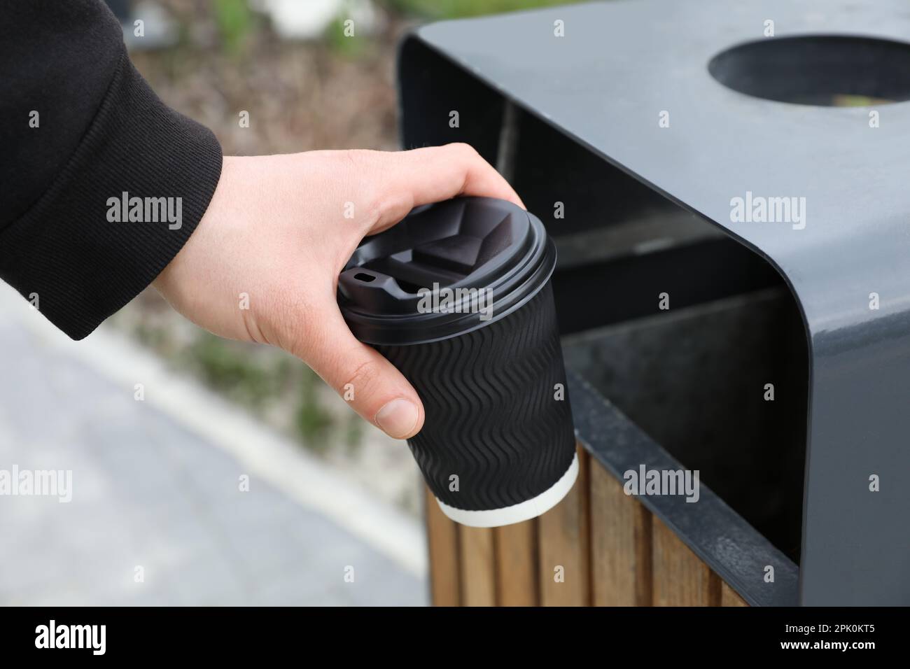 Man throwing black paper cup into trash can outdoors, closeup Stock ...