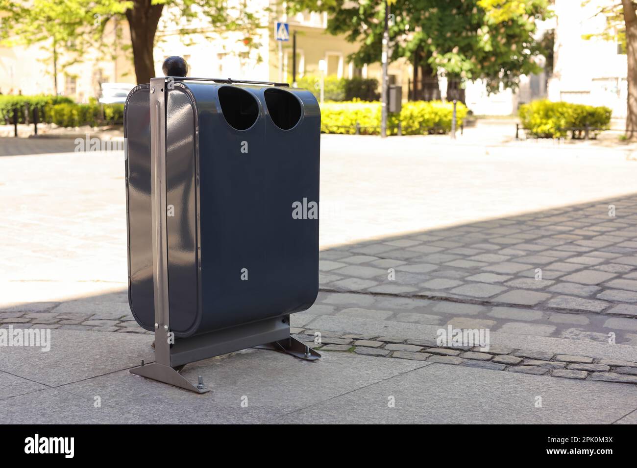 Modern metal recycling bin on city street. Space for text Stock Photo ...