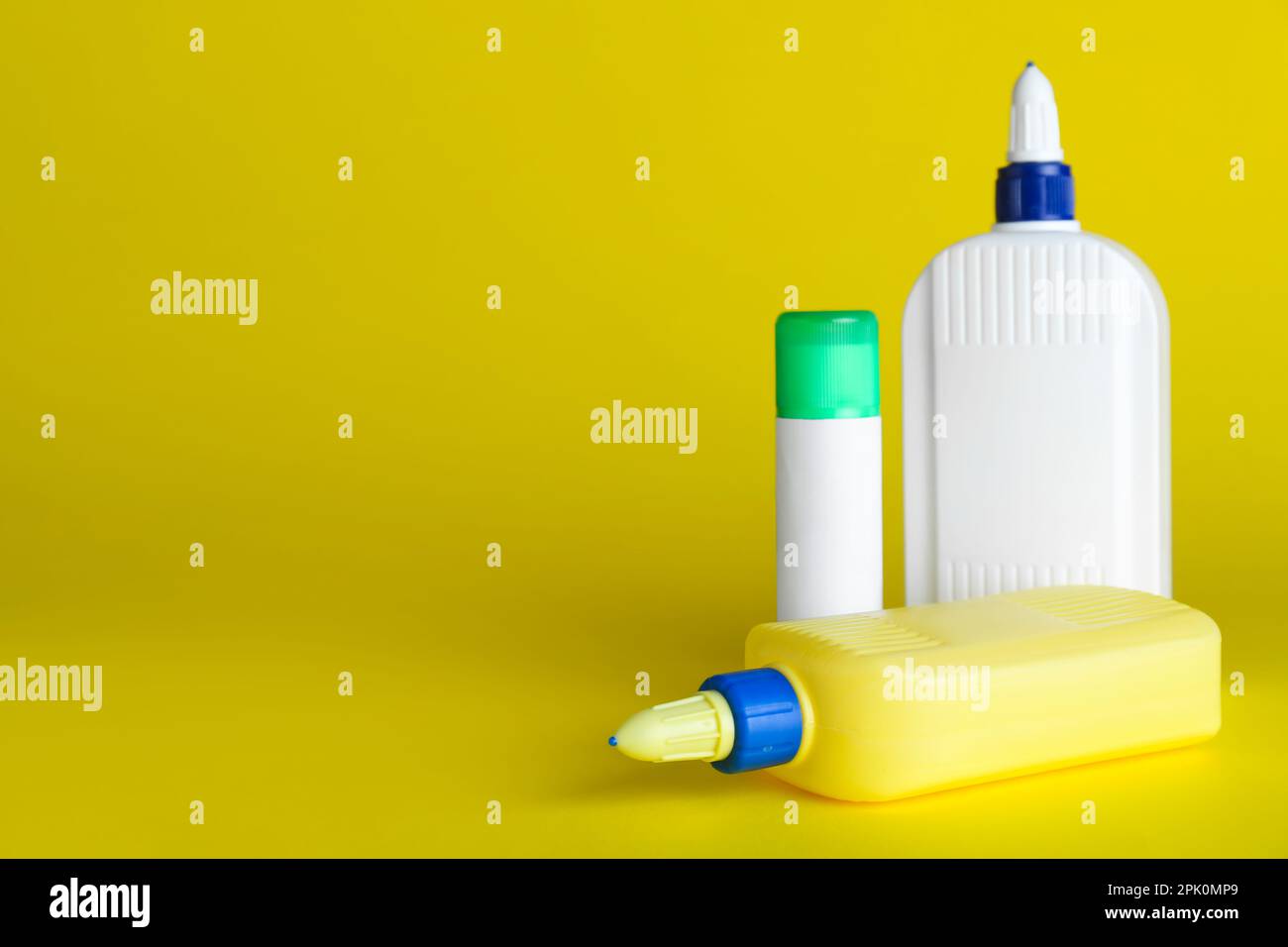 Different glues on yellow background, space for text Stock Photo - Alamy