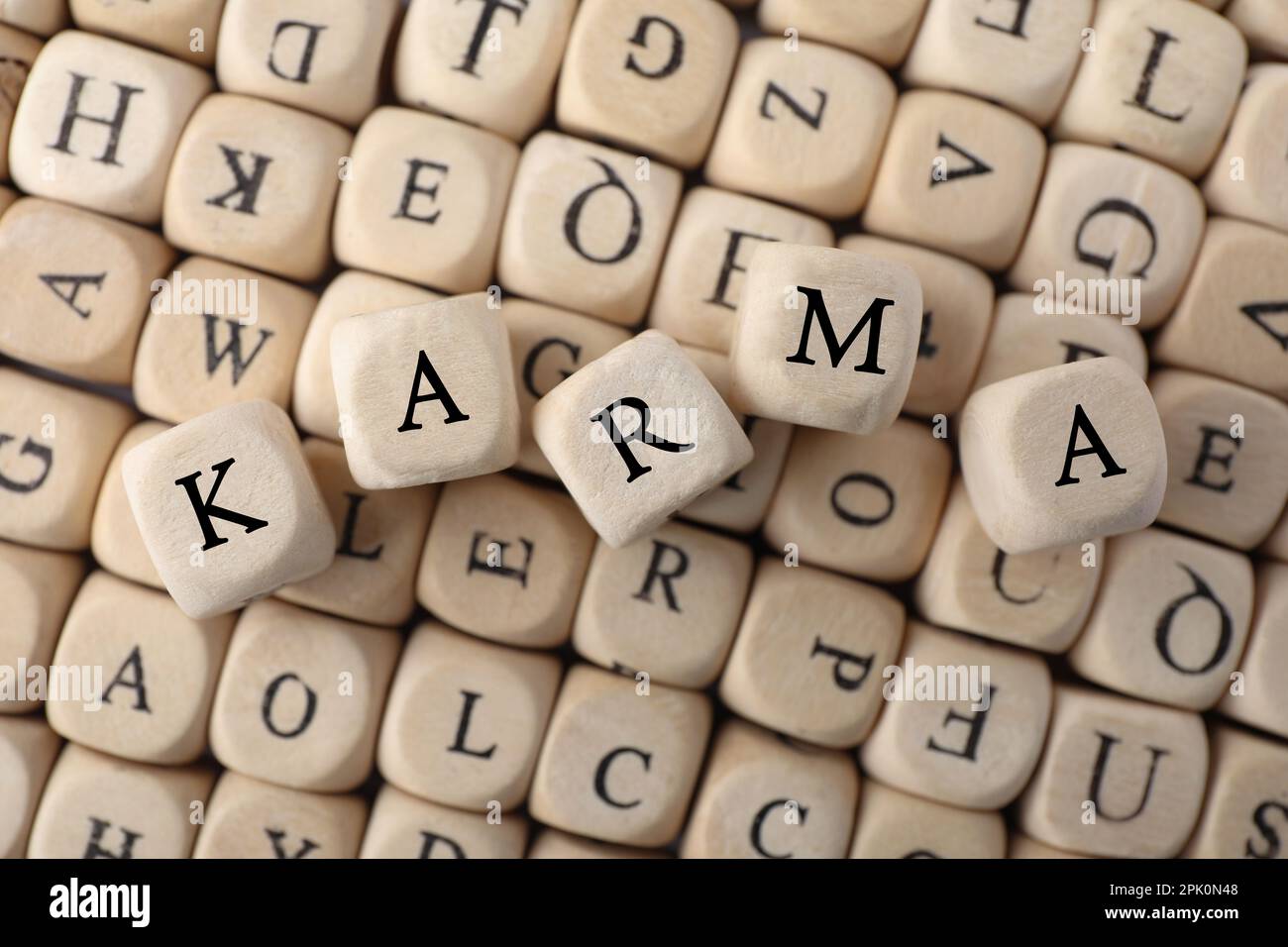 Many cubes with letters and some of them making word Karma, top view ...