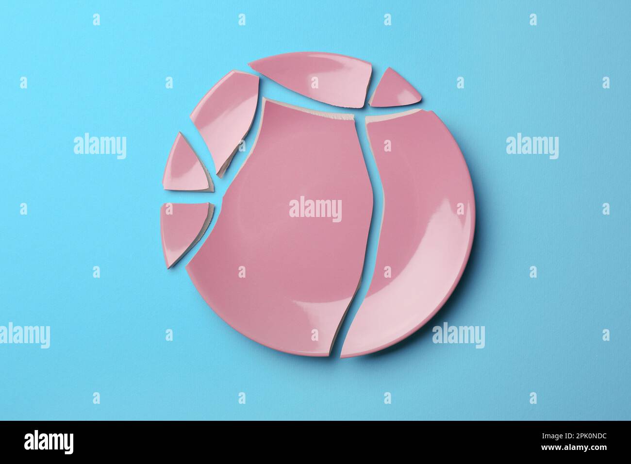Pieces of broken ceramic plate on light blue background, flat lay Stock ...
