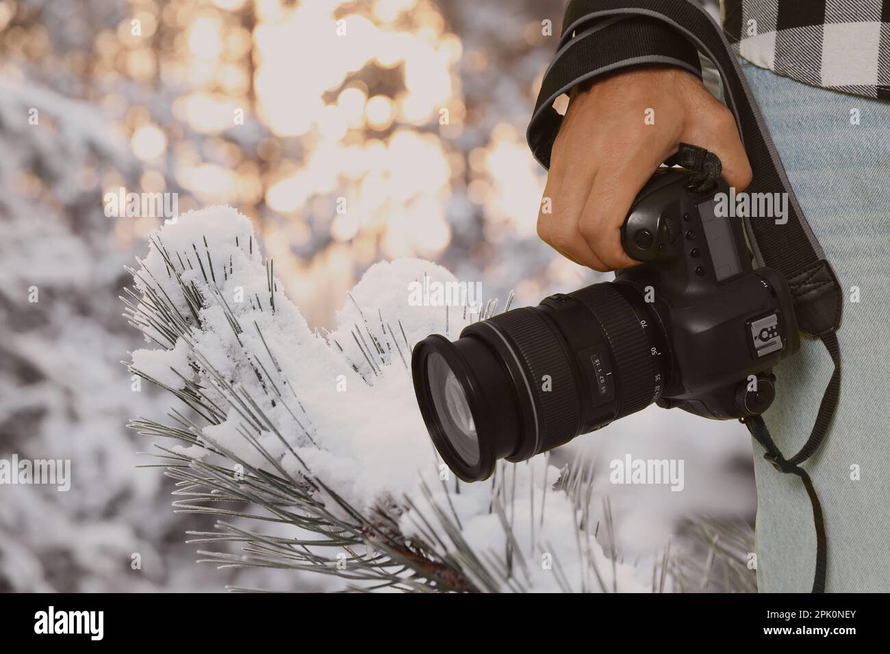 Professional photographer with modern camera and blurred view of snowy ...